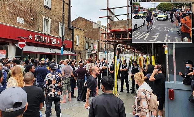Moment mob armed with makeshift weapons brawl on north London street ...